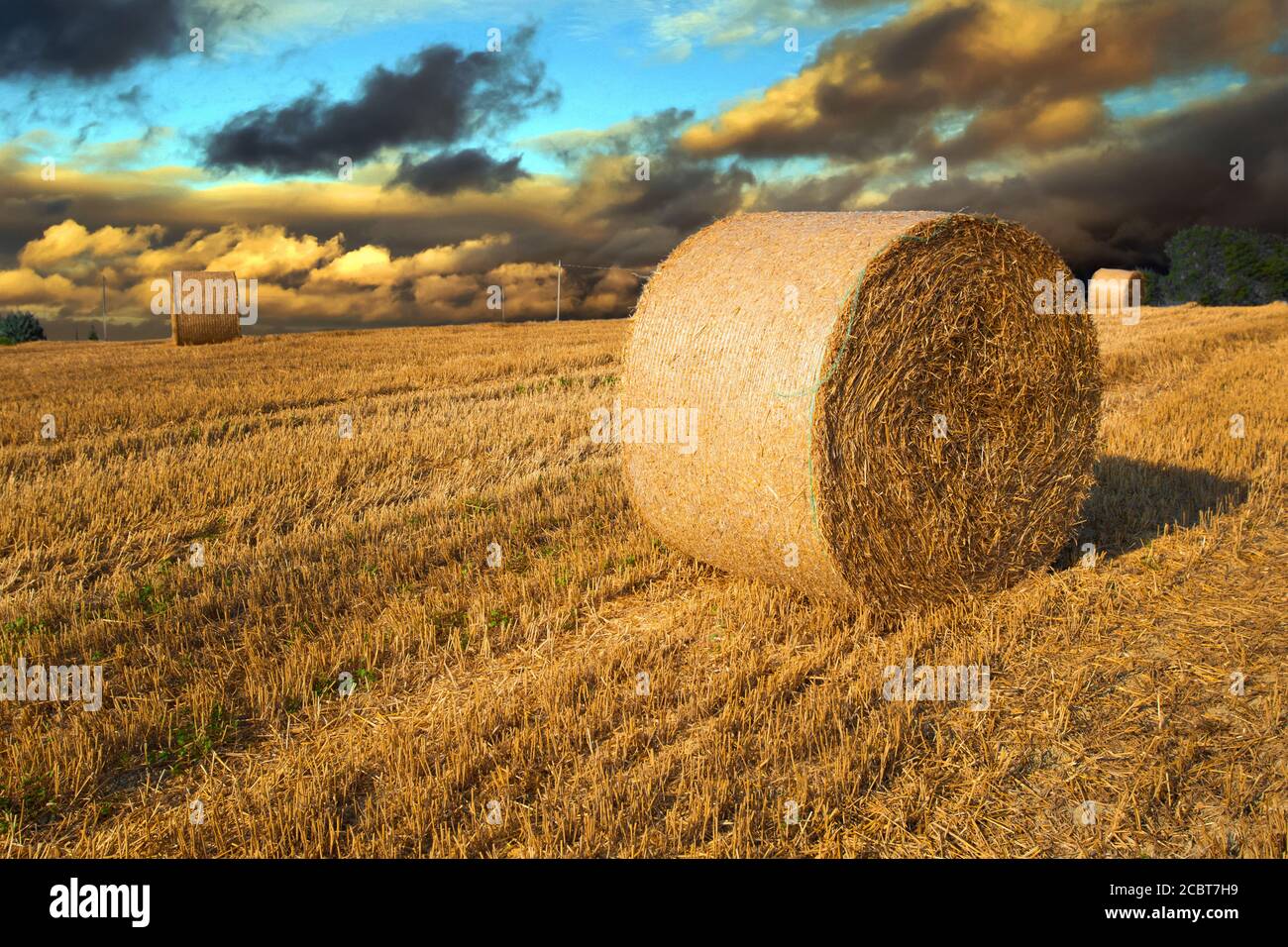 Golden sunset over farm field with hay bales Stock Photo - Alamy