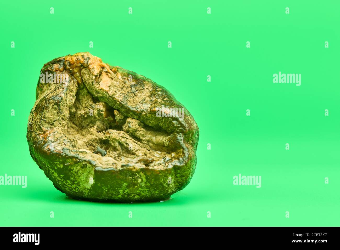 Rotten lemon, green background. Mold putrefied fruit yellow and green ...