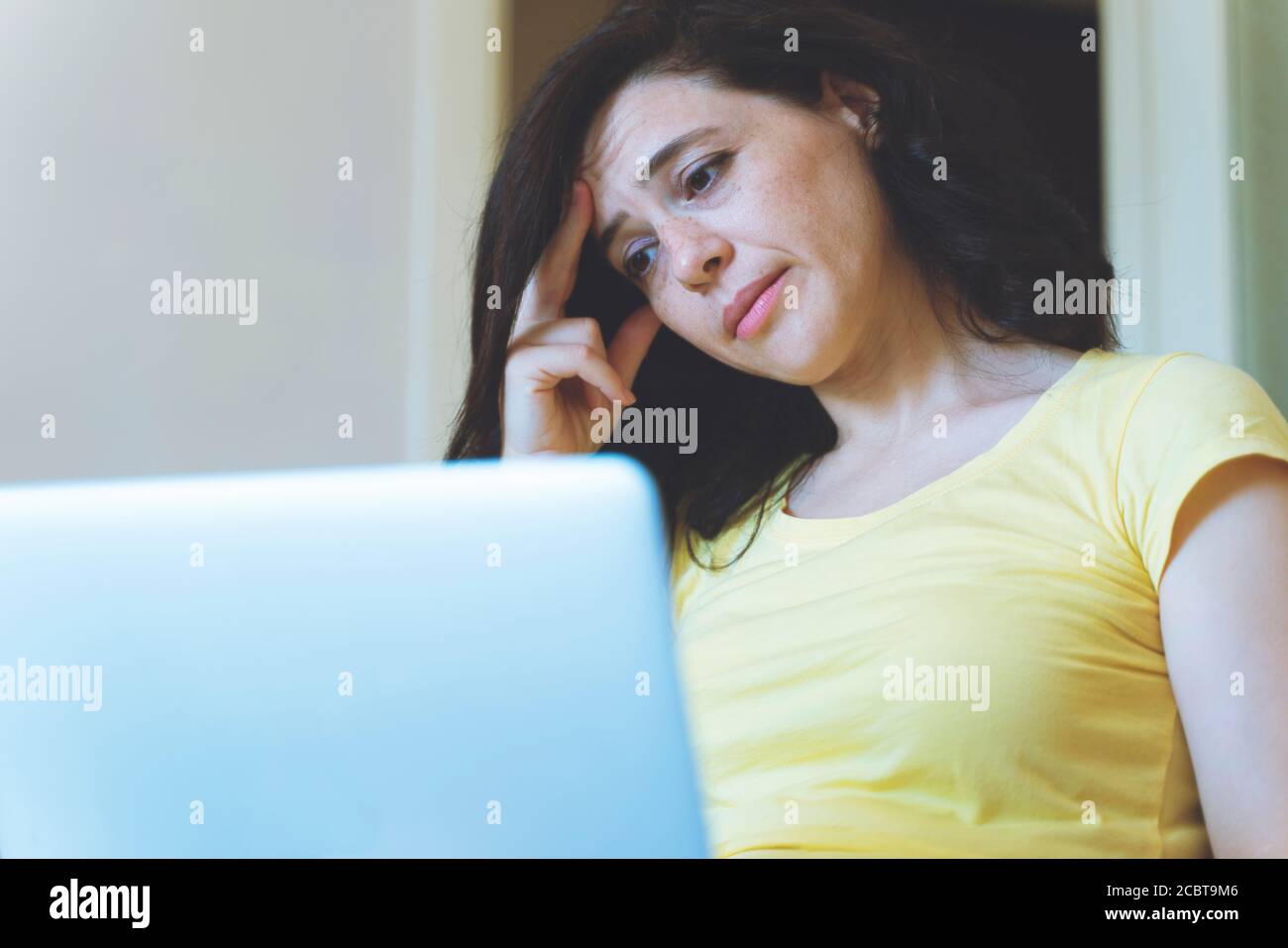 Women laptop home worried hi-res stock photography and images - Alamy