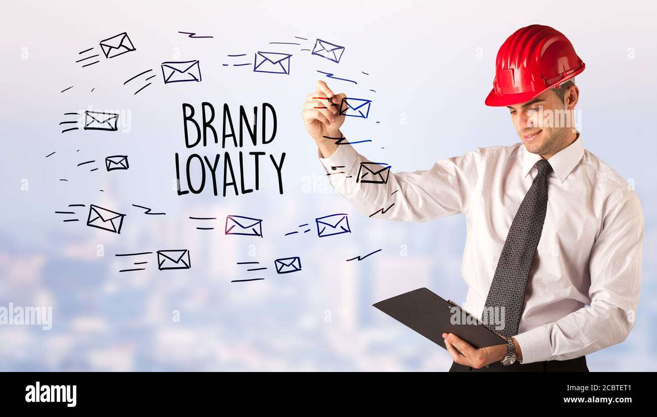 Handsome businessman with helmet drawing BRAND LOYALTY inscription ...