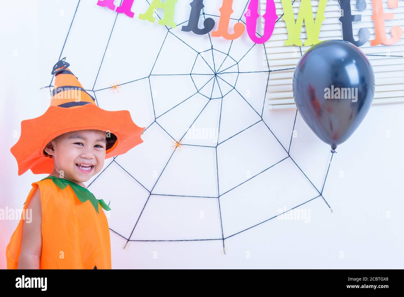 Funny happy kid in Halloween costume with pumpkin Jack with Cobweb on ...