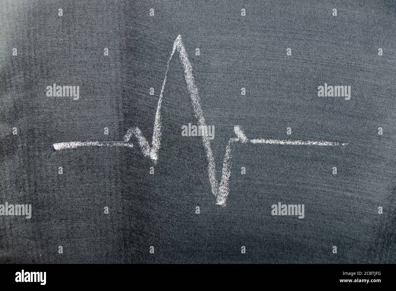 White color chalk hand drawing in pulse rate shape on black board ...