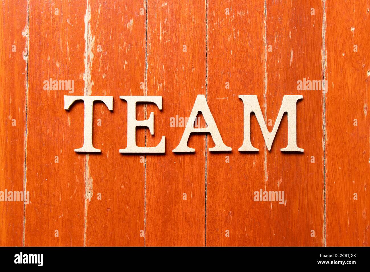 Alphabet letter in word team on old red color wood plate background ...