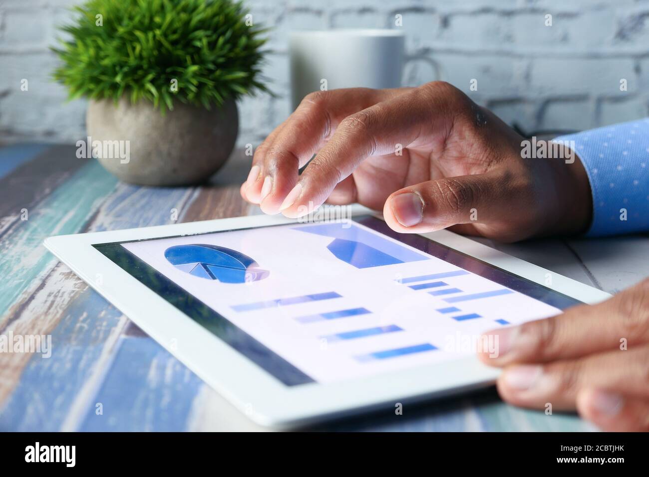 man's hand working on digital tablet at office desk, using self created ...