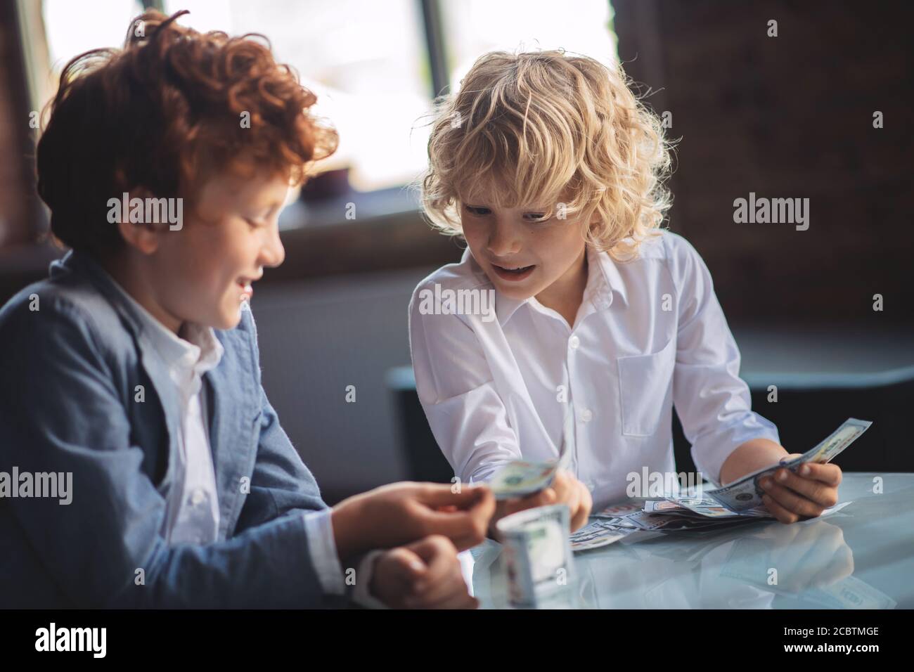 Two friends counting saved money and looking excited Stock Photo - Alamy