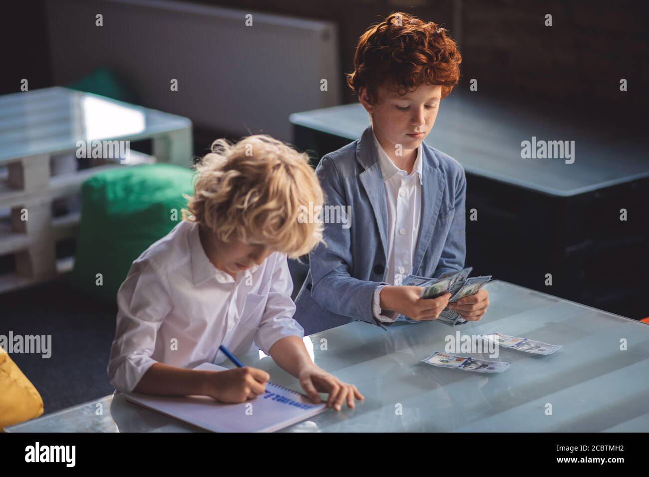 Two friends counting saved money and looking involved Stock Photo - Alamy