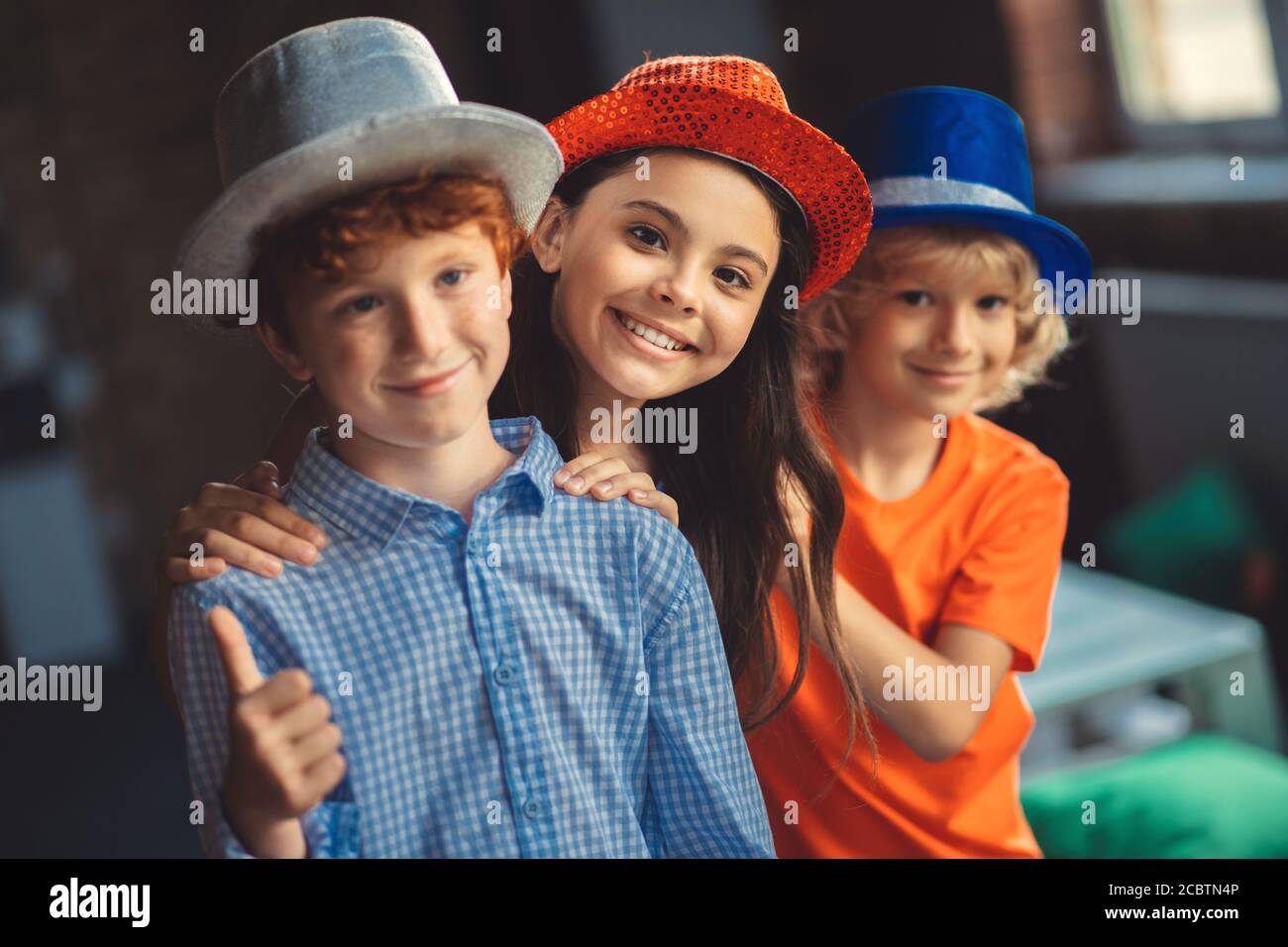 Three friends in party hats posing for the photo Stock Photo - Alamy