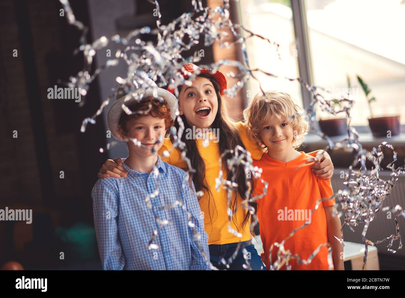 Three cute kids enjoying a birthday party Stock Photo - Alamy