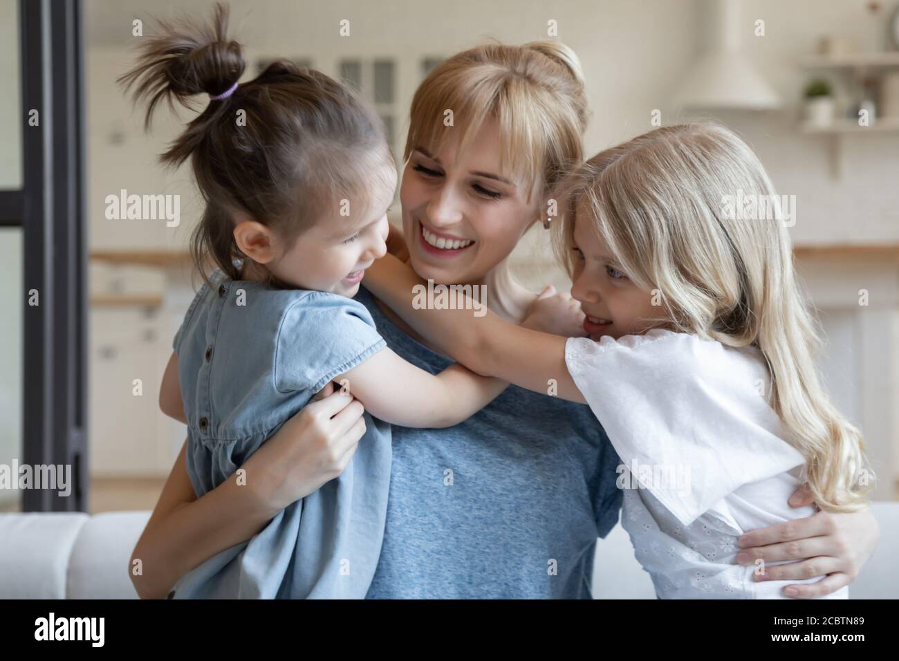 Woman and embracing two daughters hi-res stock photography and images ...