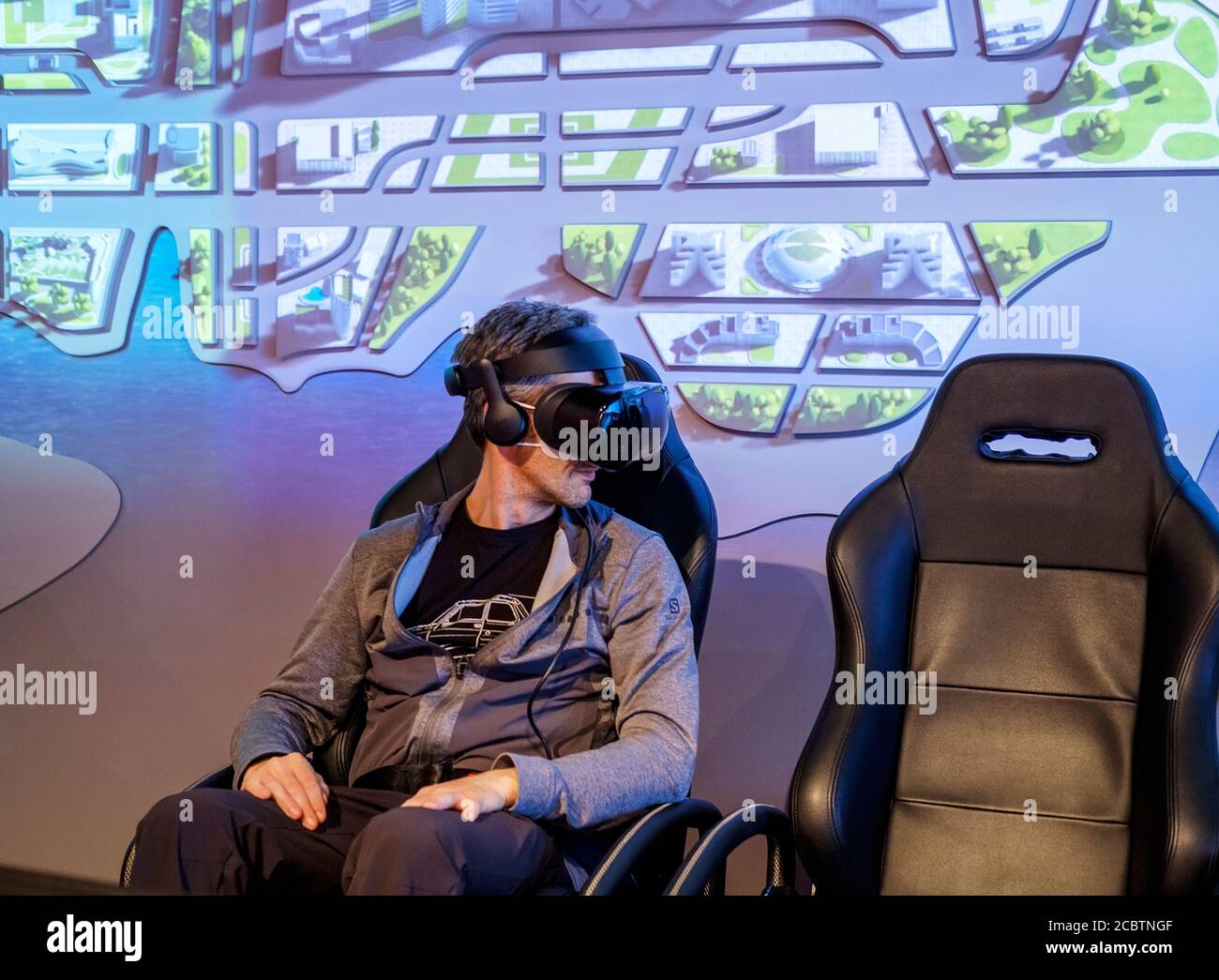 man in VR goggles sitting on a chair enjoying virtual reality ...