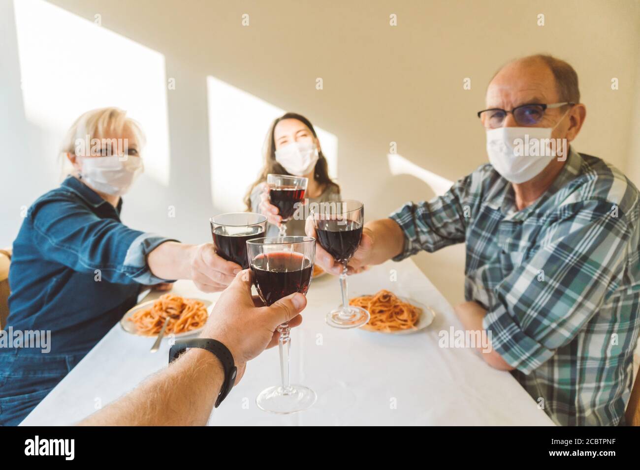POV image of people toasting with red wine glasses during dinner ...