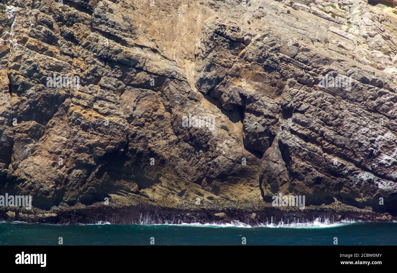 gorgeous massive cliff with ocean waves crashing its base. Beautiful ...