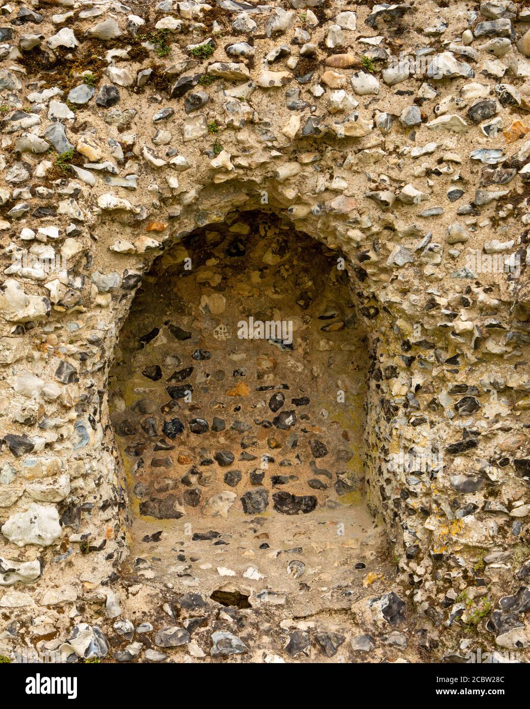 Remains of arched recess in a medieval wall made with weathered flint ...