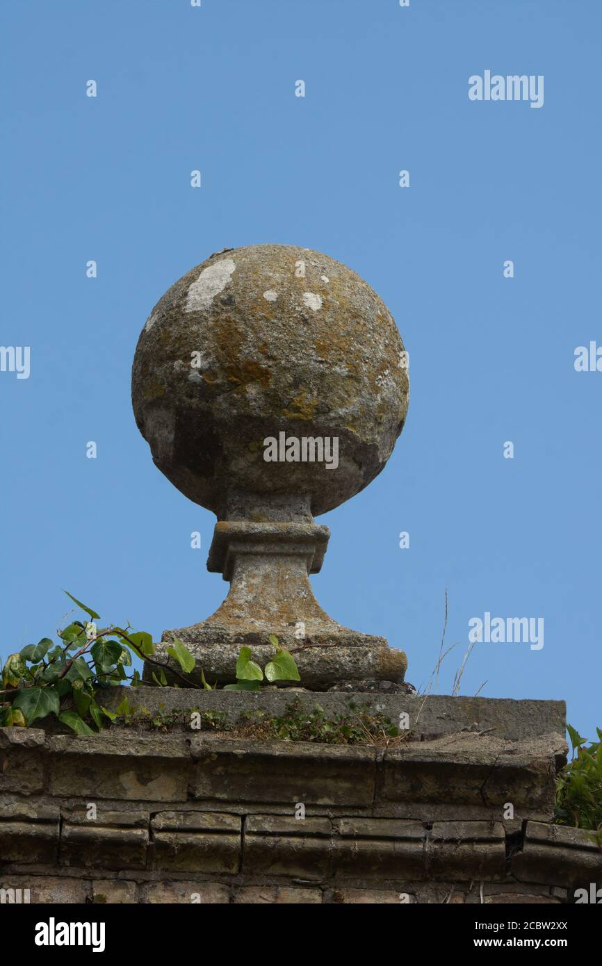 Old masonry, mossy stone ball balustrade decor against blue sky ...