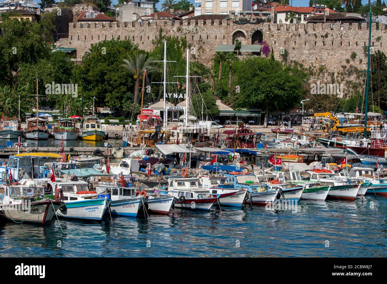 A row of fishing boats docked in the Roman Harbour in the old town of ...