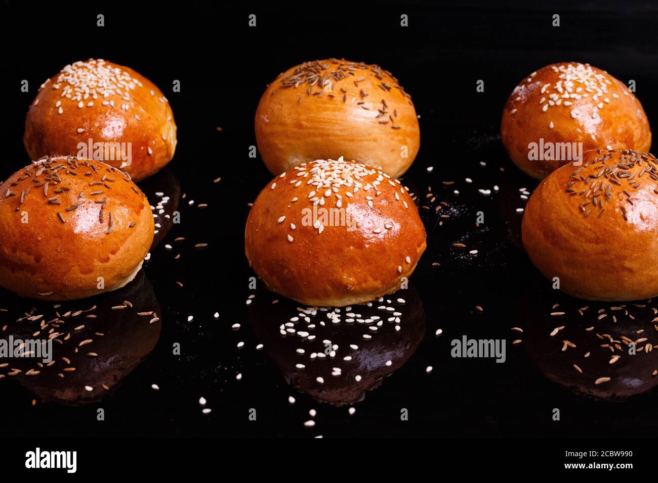 White crispy buns with sesame seeds. Photo on a black background Stock ...