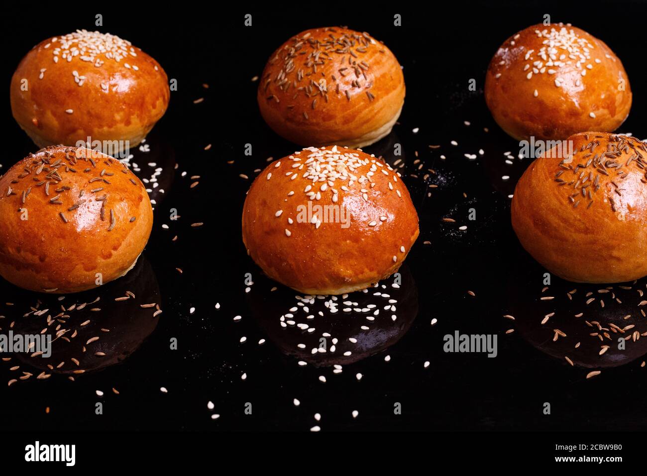 White crispy buns with sesame seeds. Photo on a black background Stock ...