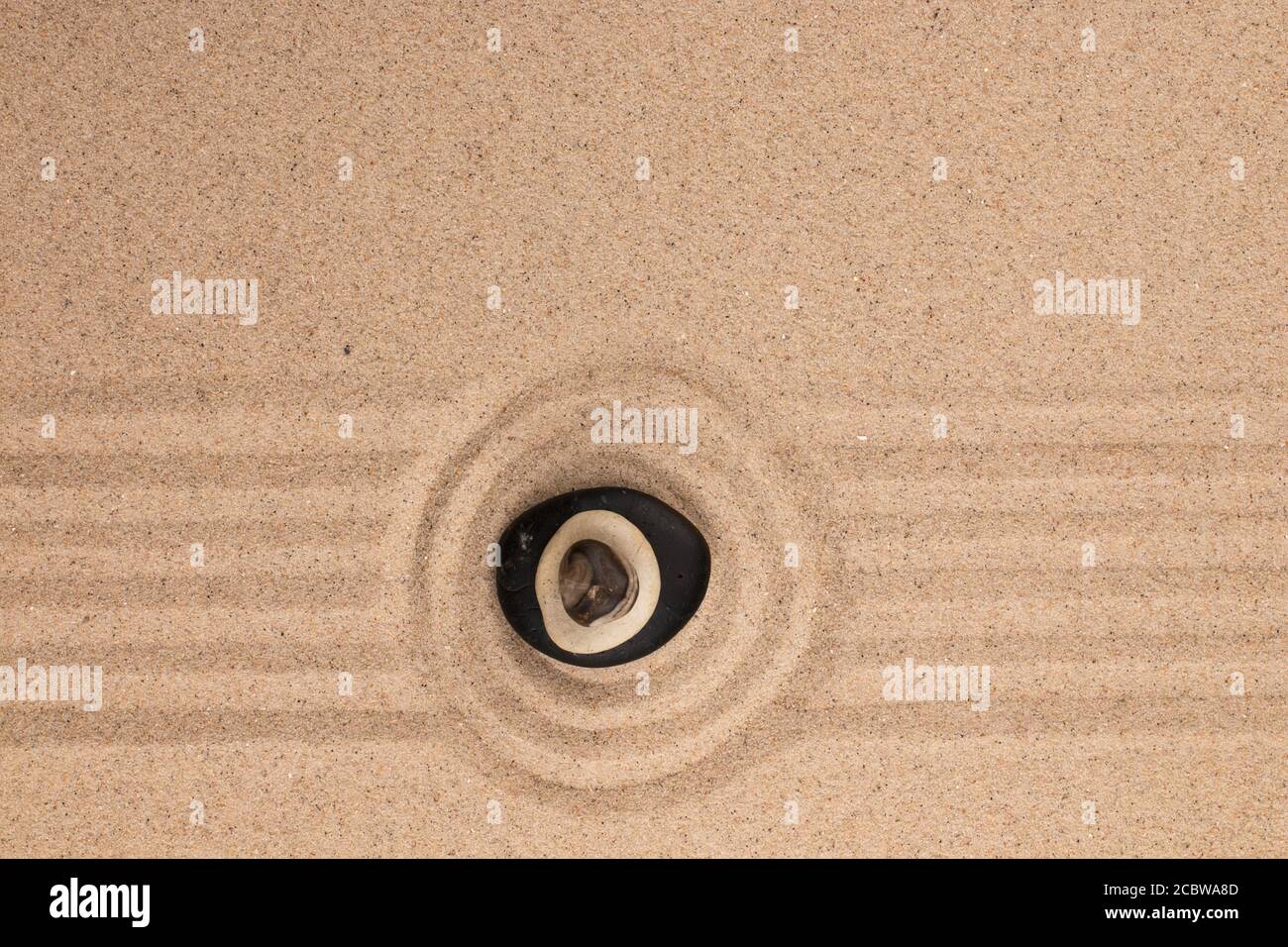 Pyramid of stones stands in the center of a sandy circle. Top view ...