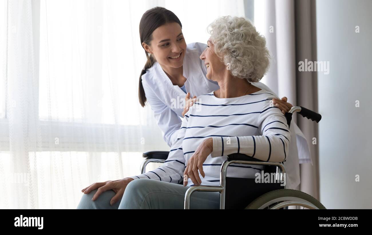 Professional young female medical worker communicating with disabled ...