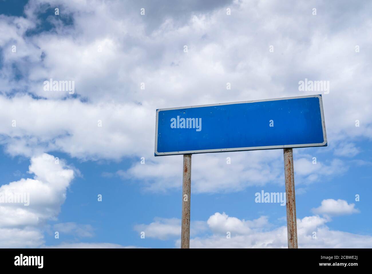 empty country road sign, a pointer on a background of blue cloudy sky ...