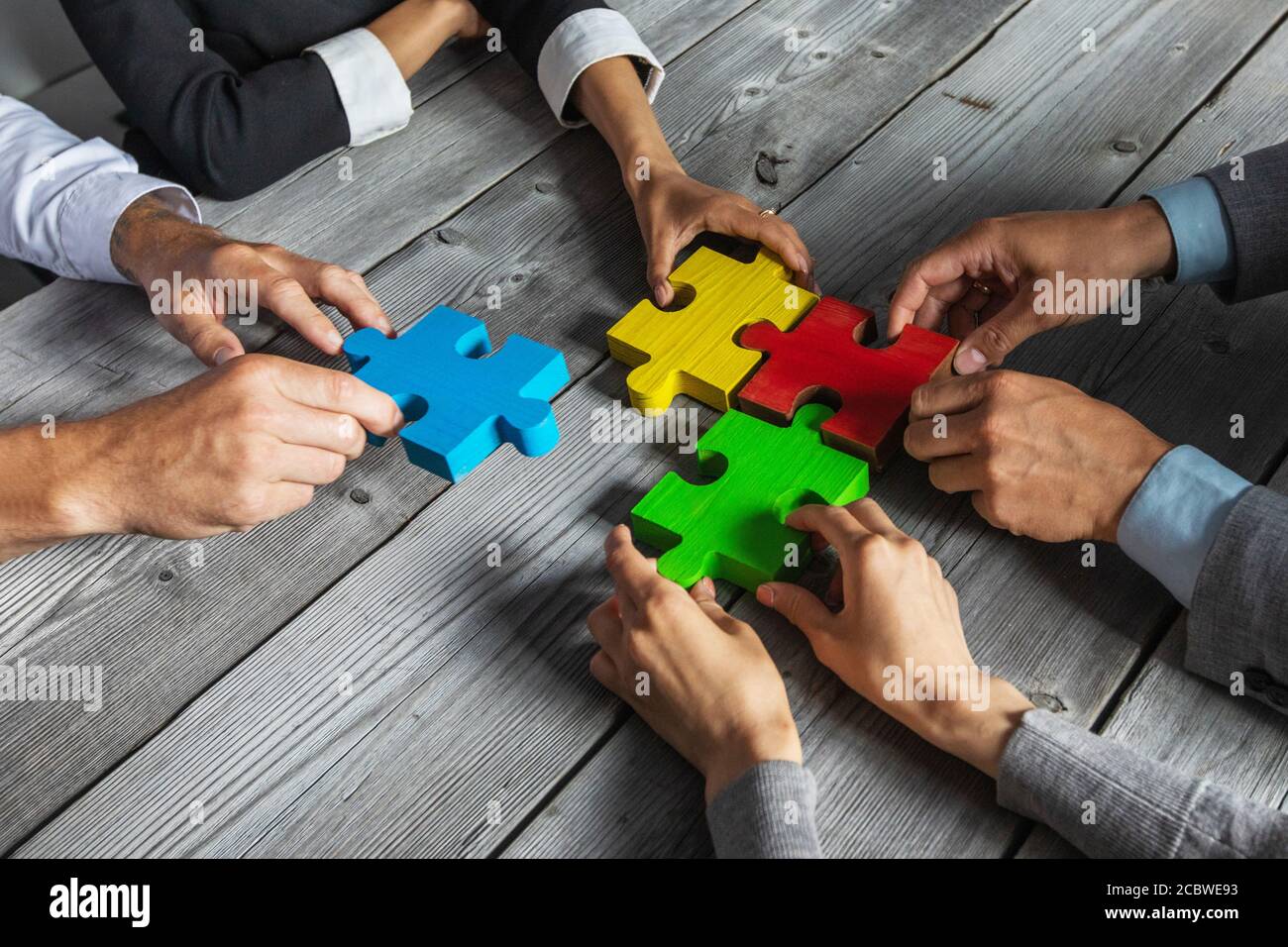 Business people team sitting around meeting table and assembling color ...