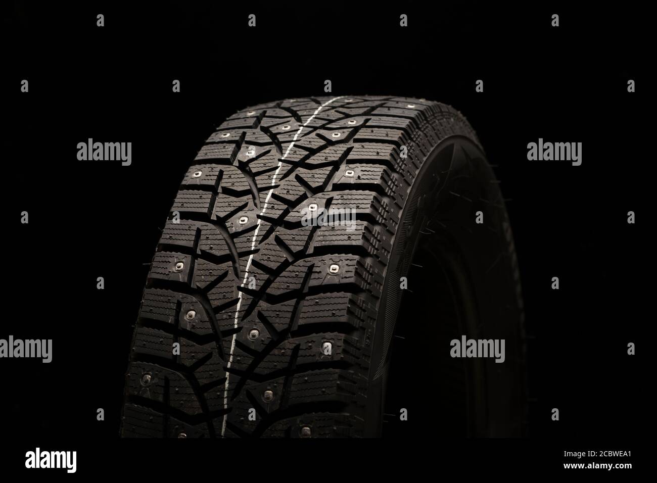 studded winter tire, side view. Close-up on a black background Stock ...