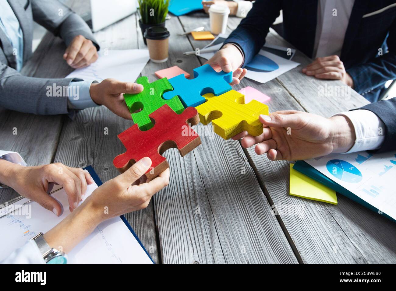 Business people team sitting around meeting table and assembling color ...