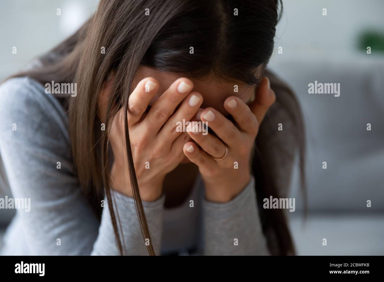 Unhappy young woman hiding face in hands, feeling desperate Stock Photo ...