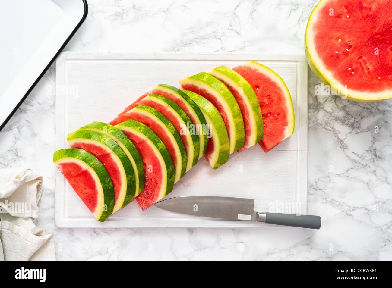 Slicing red seedless watermelon on a white cutting board Stock Photo ...