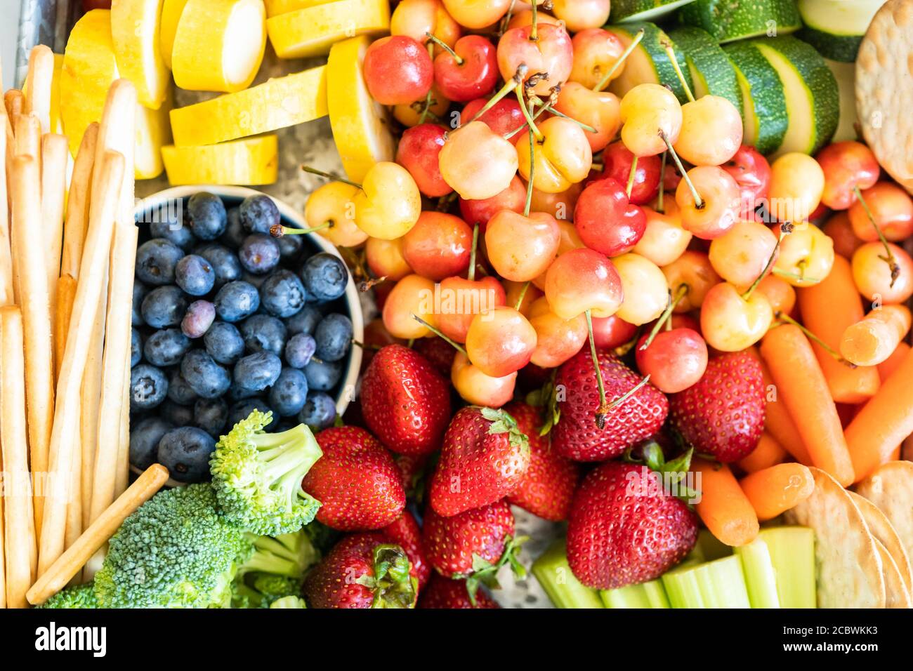 Snack board with fresh fruit, vegetables, crackers, and dips Stock ...