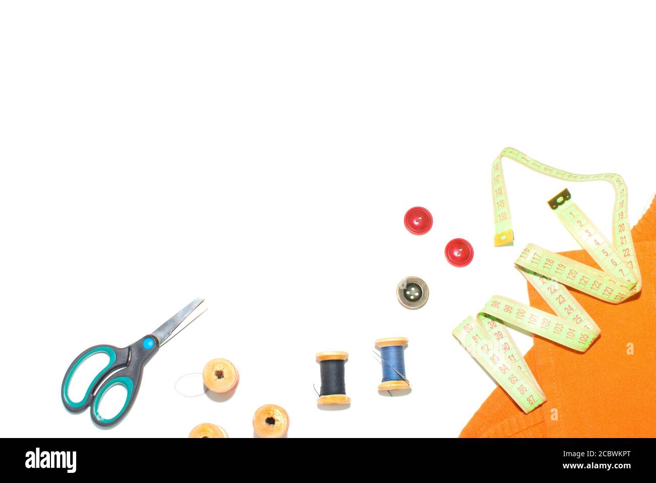 Coil with thread, scissors and ruler on a piece with a bright cloth, on ...