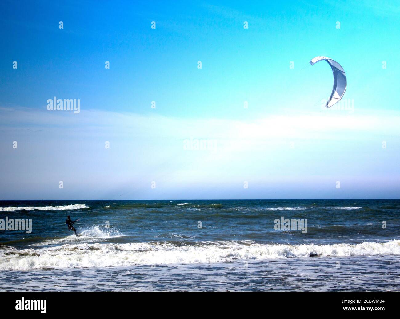 Kitesurfer jumping on a beautiful background of spray during the sunset ...
