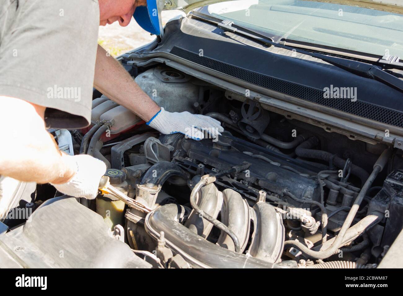 Surprised mechanic looks inside the car Stock Photo - Alamy