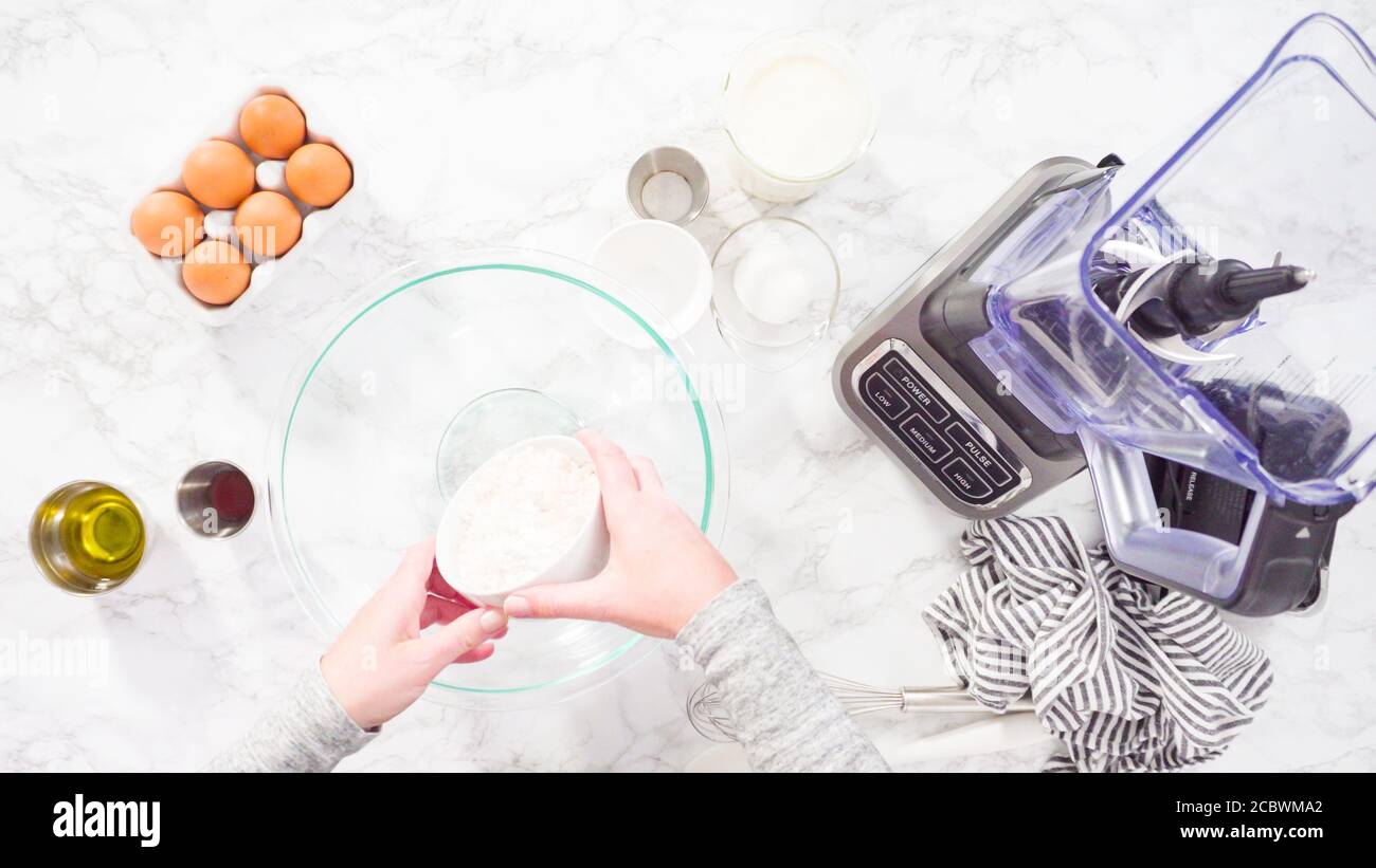 Flat lay. Mixing ingredient in a glass mixing bowl to make the crepes ...