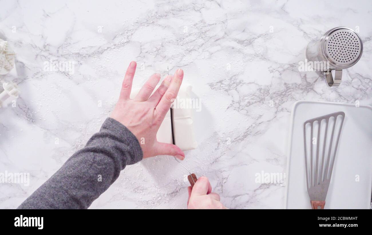 Flat lay. Step by step. Rolling our white fondant on a marble counter ...