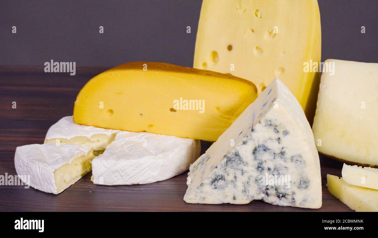 Large wedges of gourmet cheese on a rustic wood background Stock Photo ...
