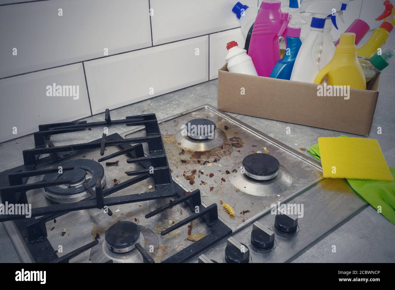 Cleaning a gas stove with kitchen utensils, household concepts, or ...