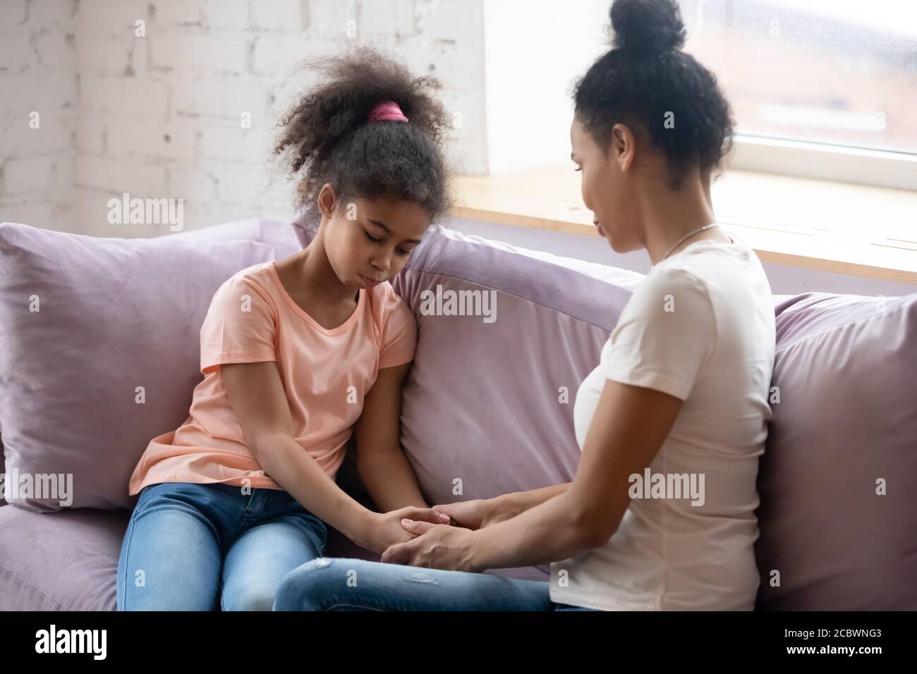 Attentive caring black mother supporting her school age daughter Stock ...