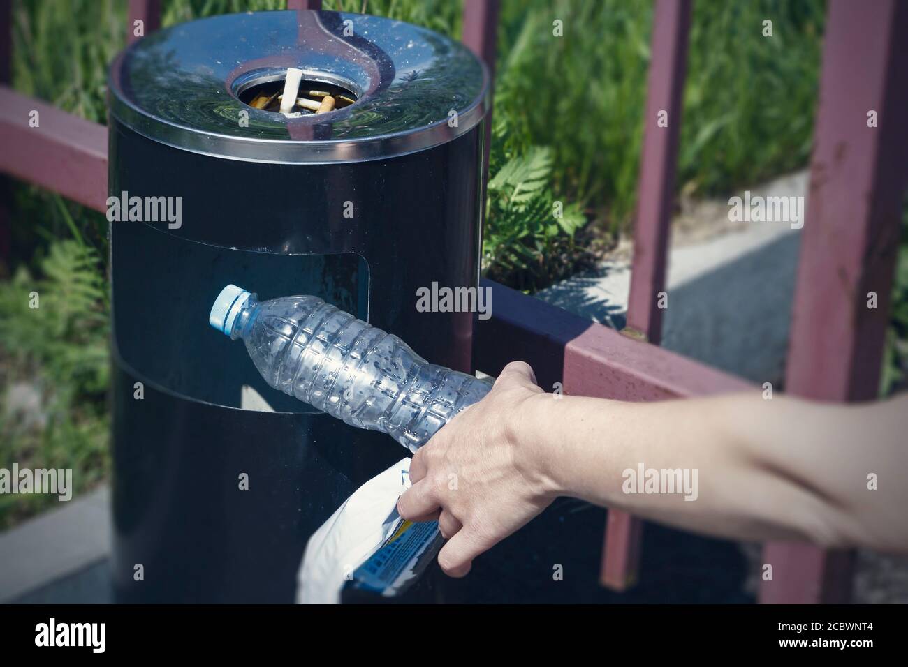Close - up of cropped portrait of someone throwing trash in the trash ...