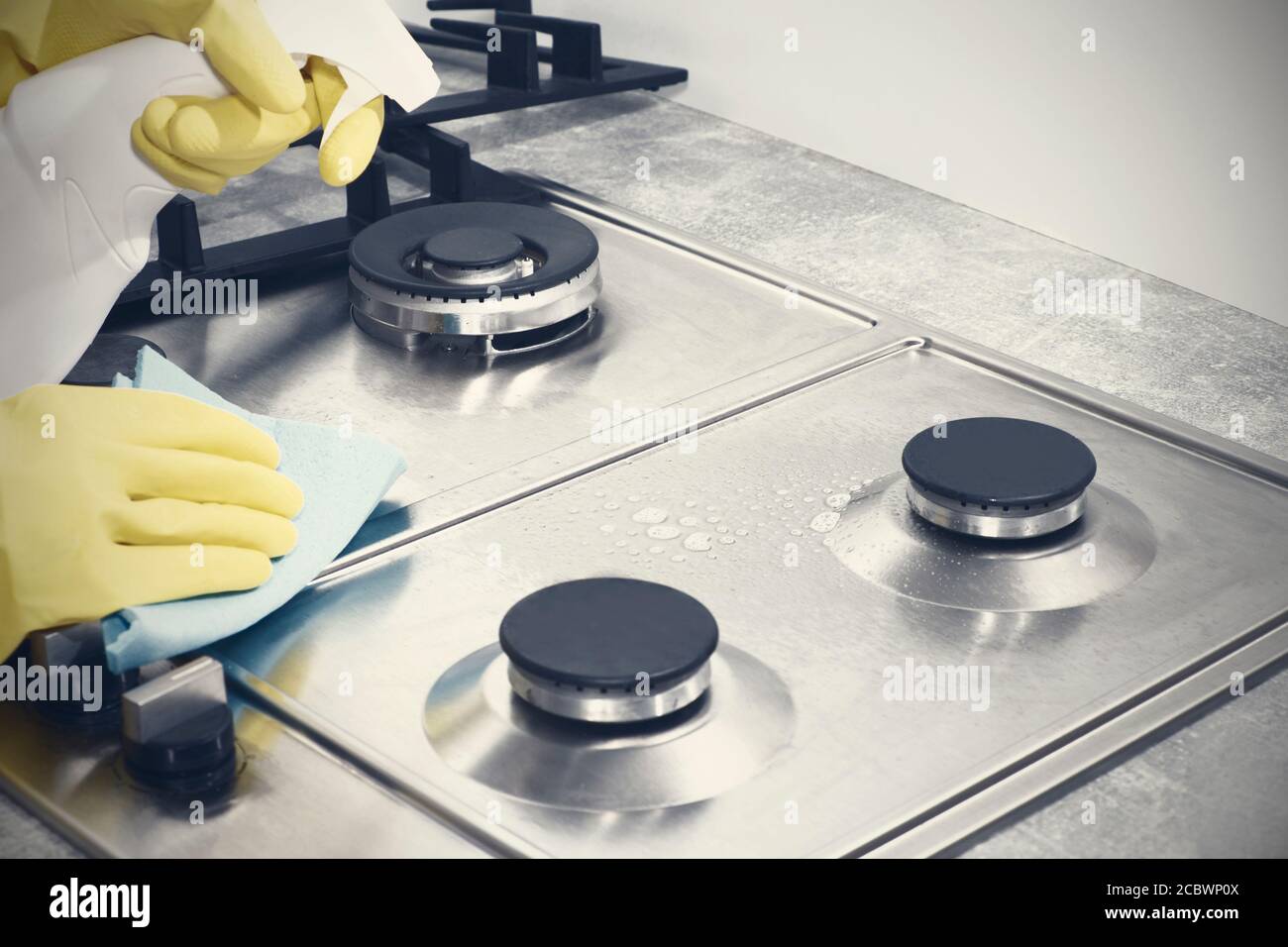 Cleaning a gas stove with kitchen utensils, household concepts, or ...