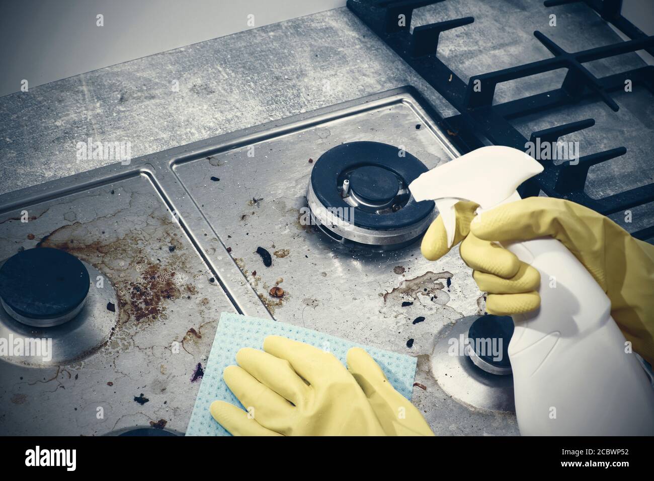 Cleaning a gas stove with kitchen utensils, household concepts, or ...