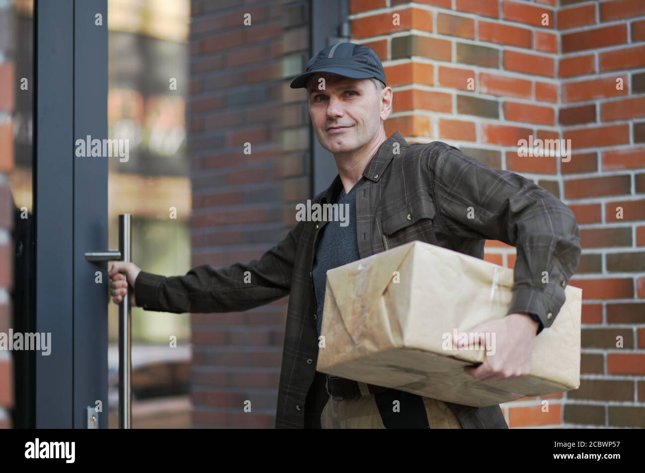 Delivery man delivering cardboard box hi-res stock photography and ...