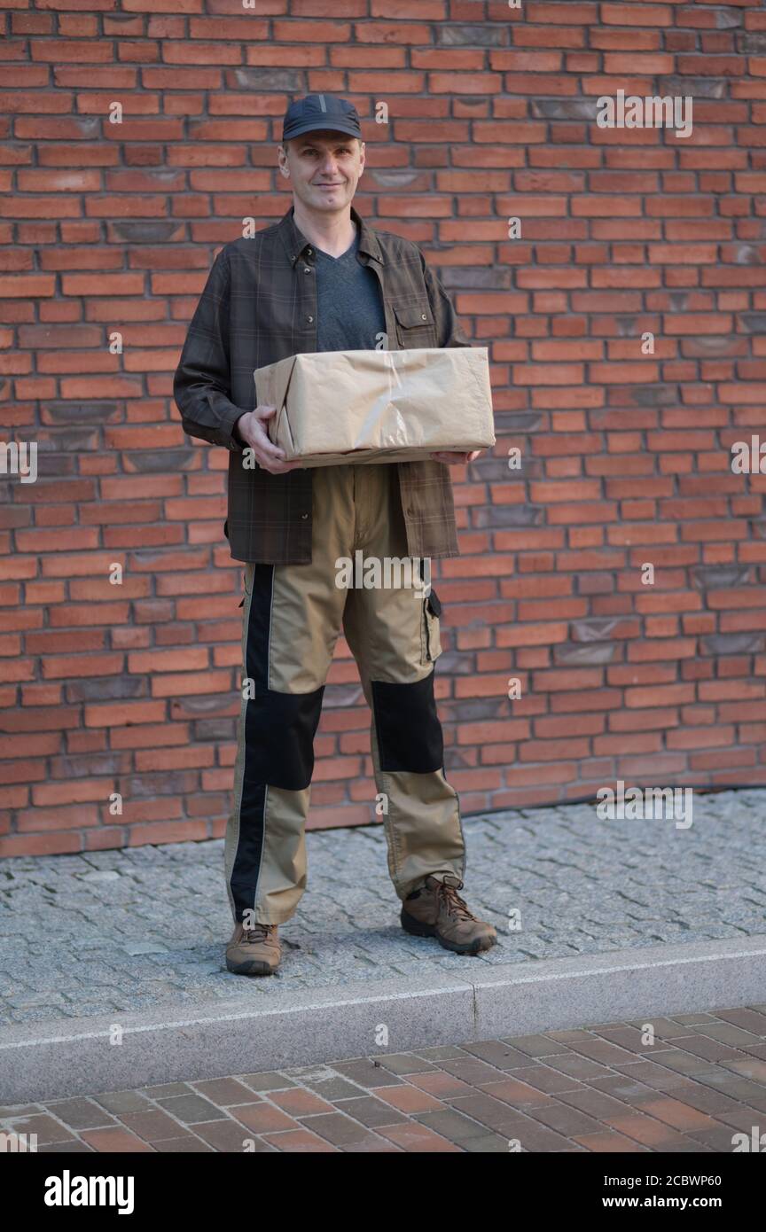 Delivery man delivering cardboard box hi-res stock photography and ...