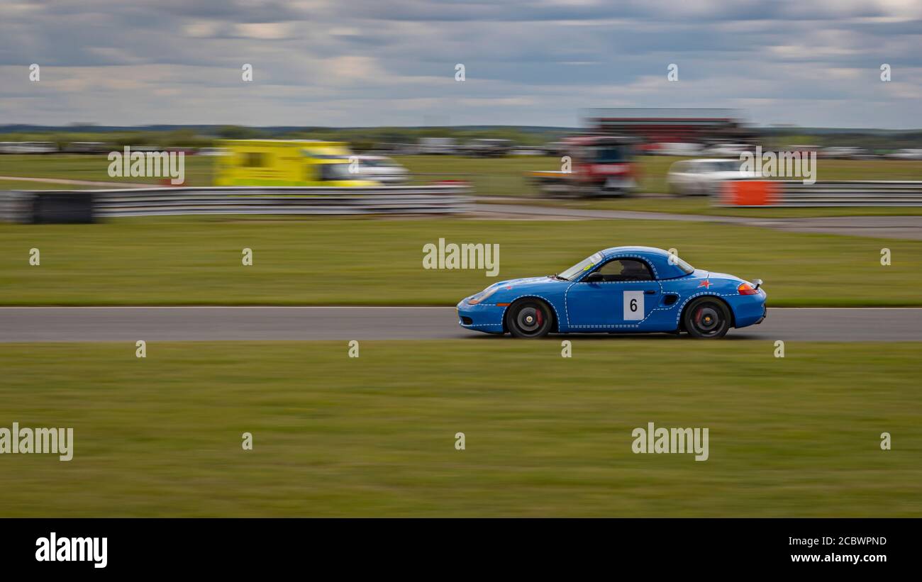 A panning shot of a blue racing car as it circuits a track Stock Photo ...