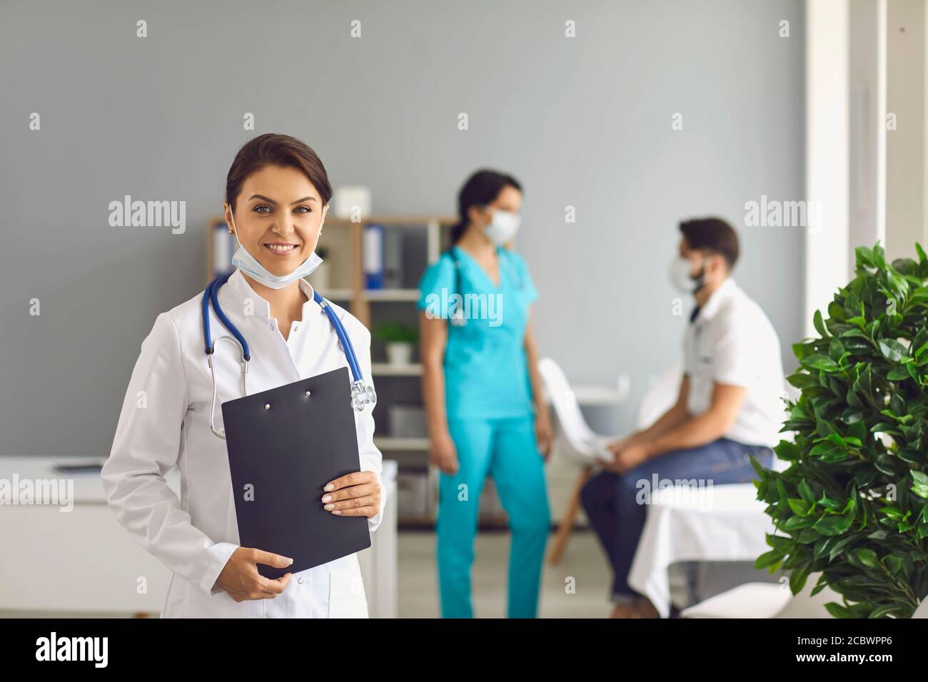Woman doctor looking at camera during patient visit Stock Photo - Alamy