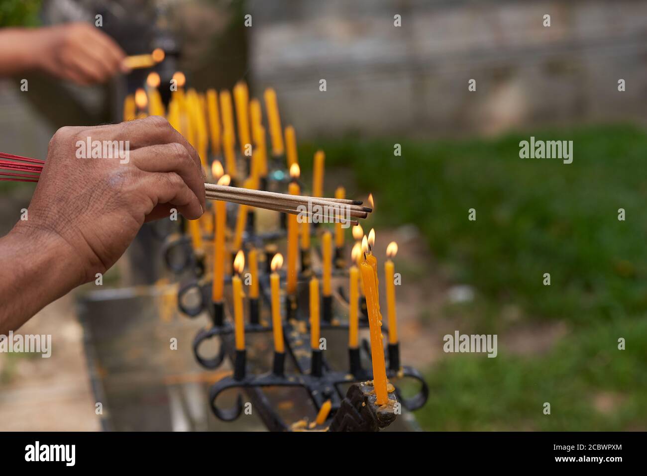 People hands burning incense from candles in the Buddhist temple Stock ...