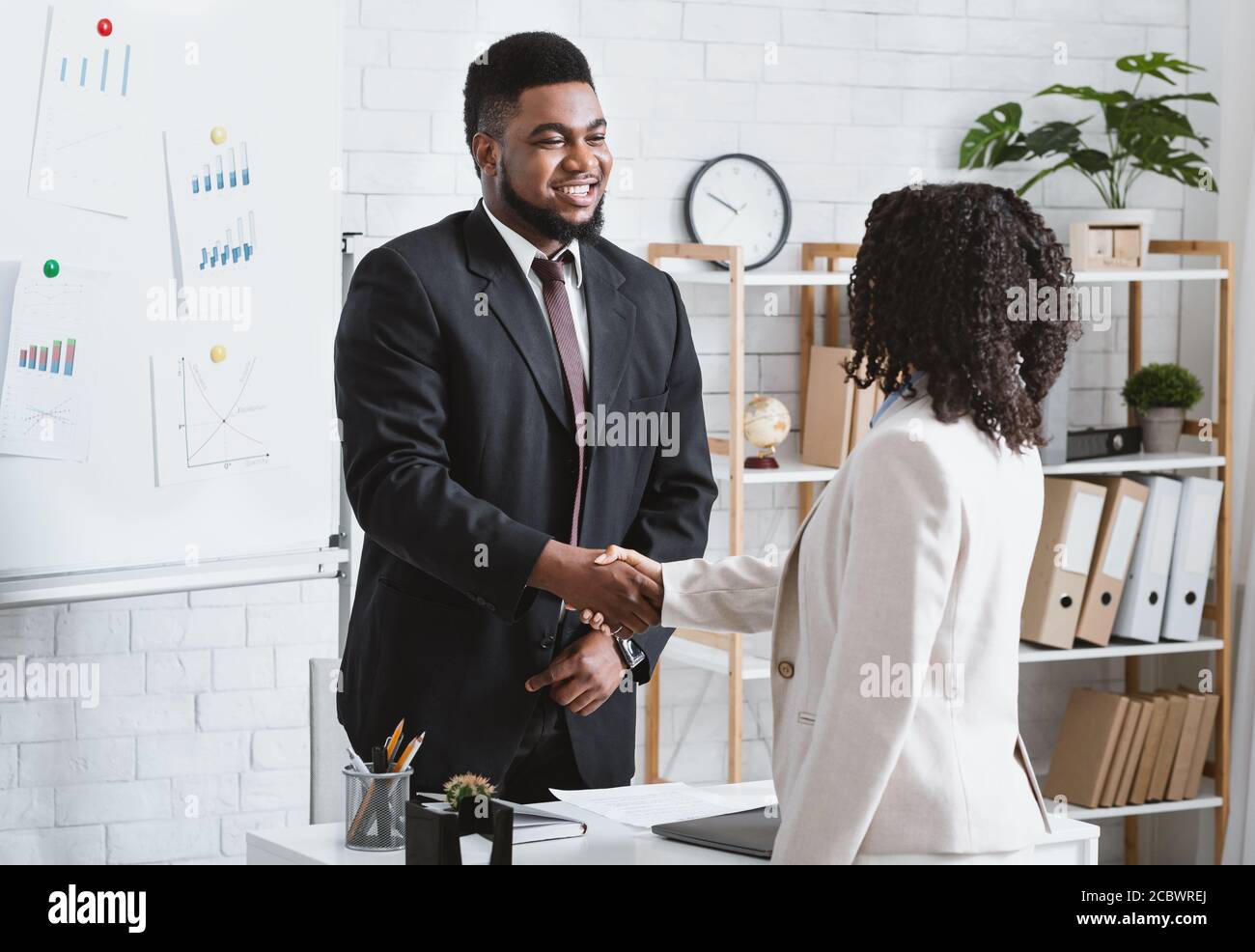 Joyful HR manager shaking hands with millennial applicant at job ...