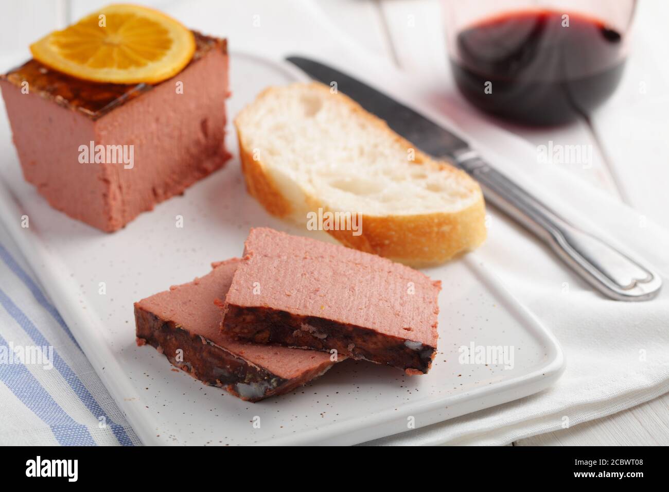 Sliced duck pate topped with orange and a slice of French baguette ...