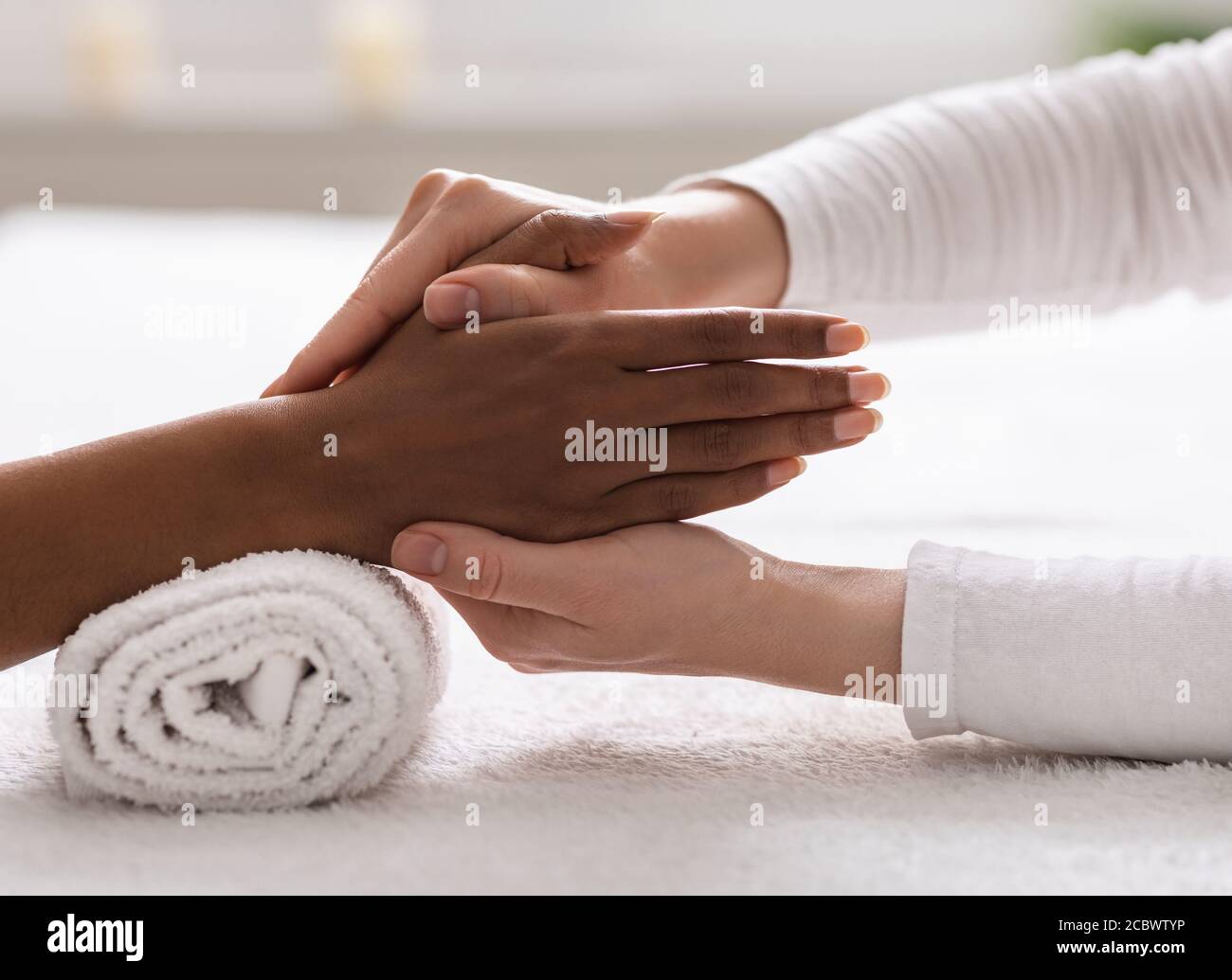 Spa therapist making reflexology hand massage for black woman Stock ...