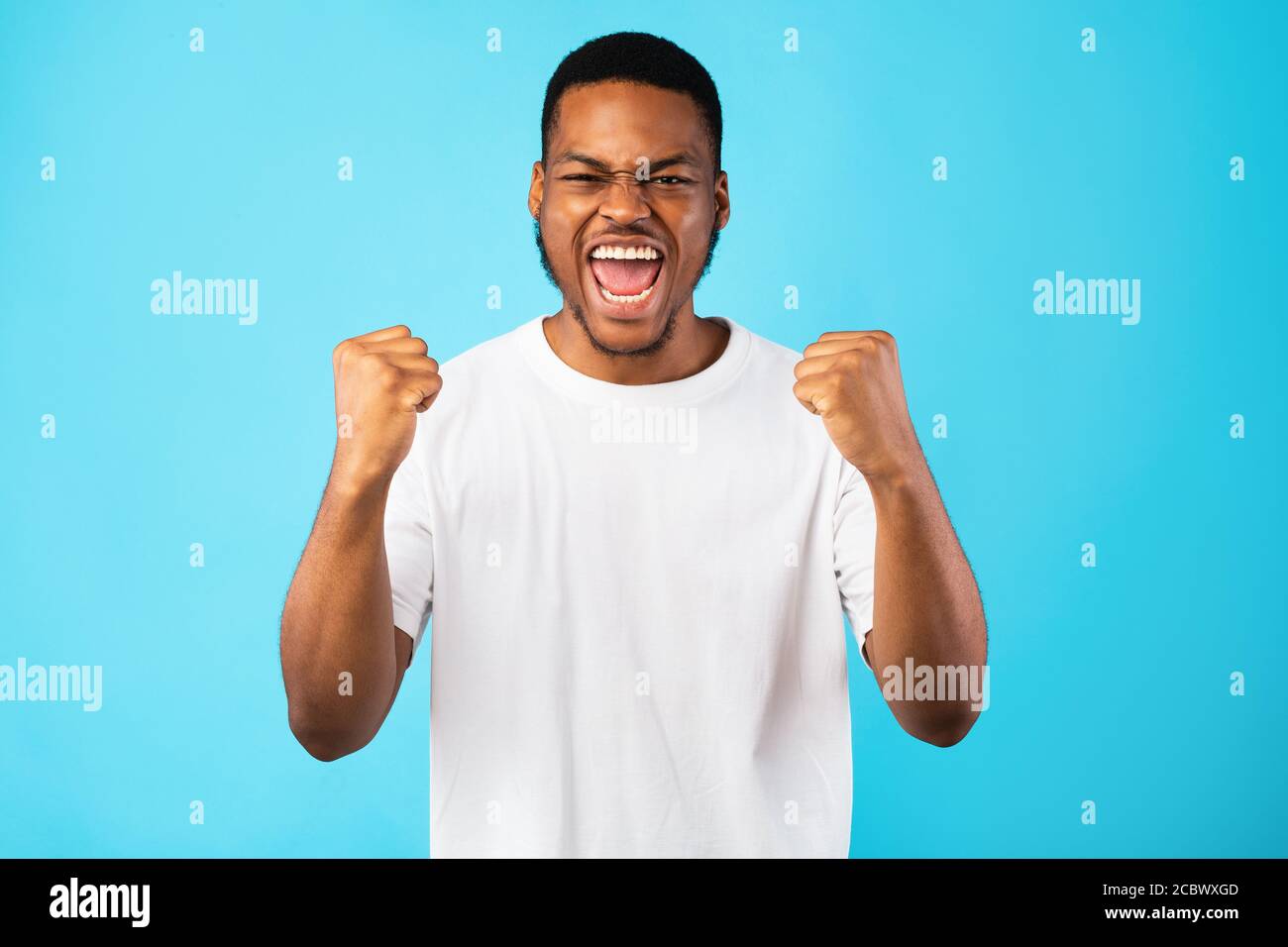 Emotional Black Guy Shouting Yes Shaking Fists On Blue Background Stock ...